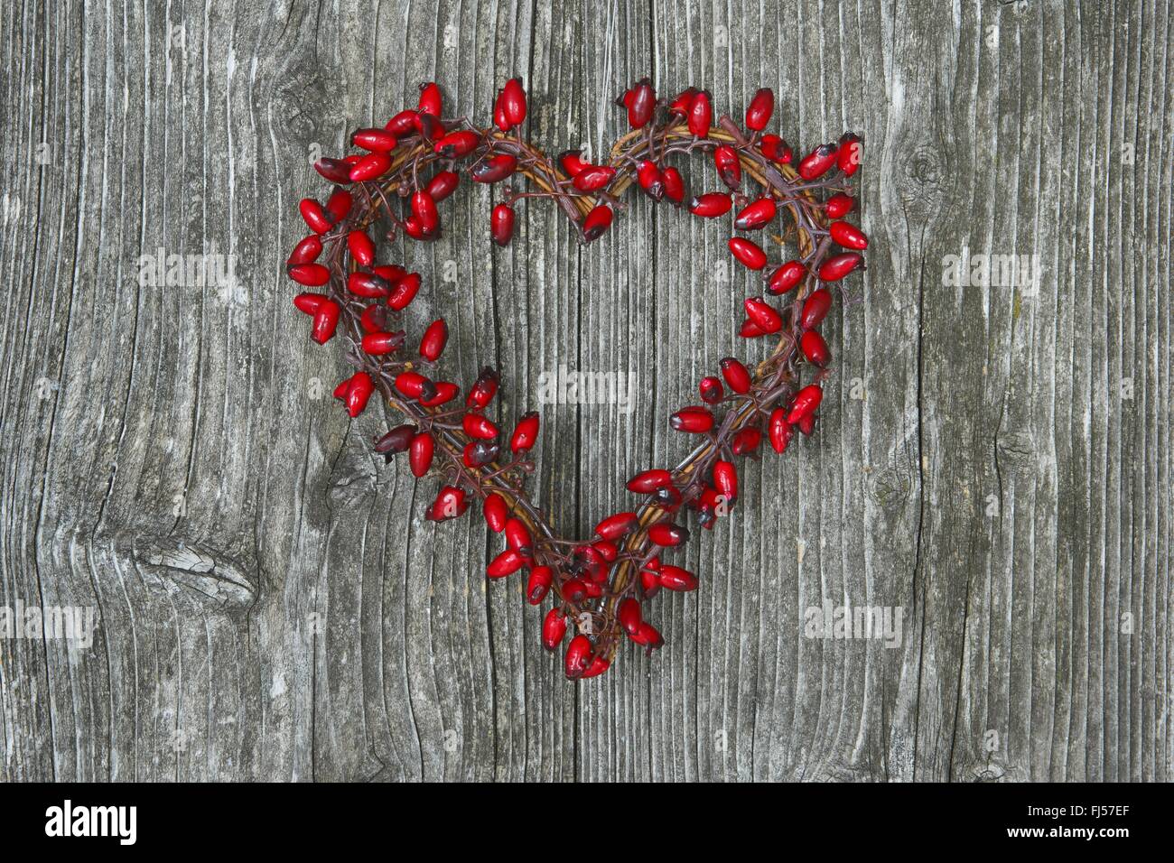 heart-shaped rose-hip crest at a wooden door Stock Photo - Alamy