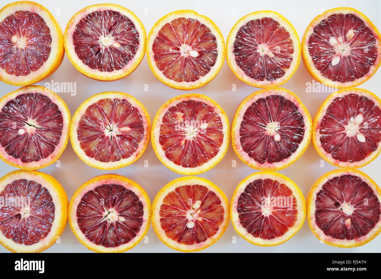 Plate of colorful blood oranges cut in half Stock Photo - Alamy
