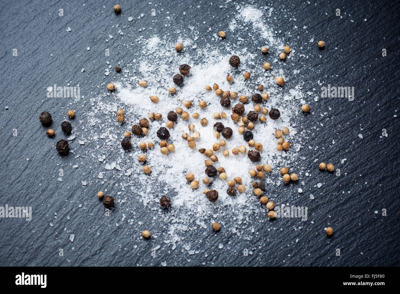 Salt, pepper on a chopping board. Top view Stock Photo - Alamy