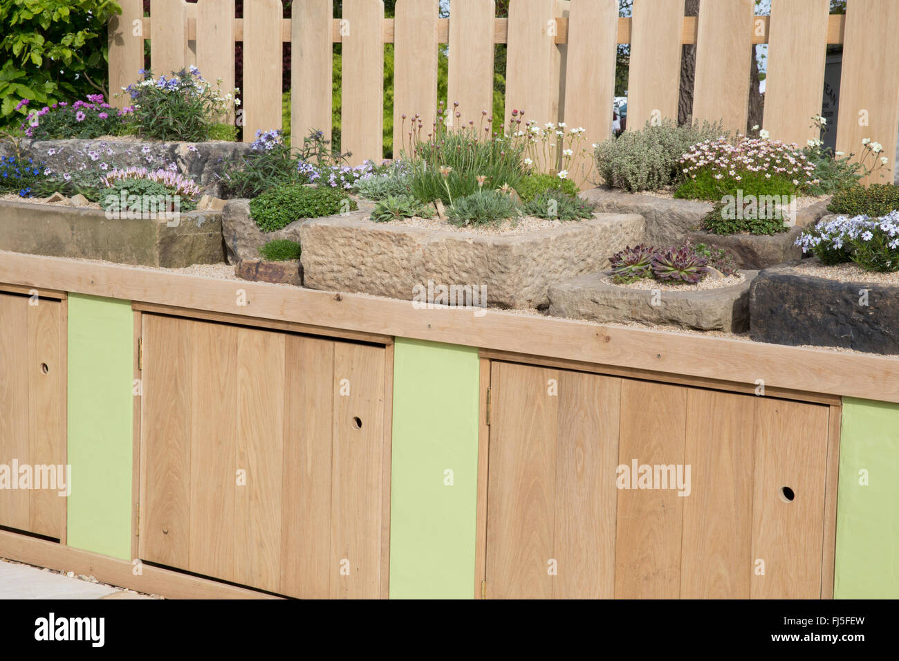 Patio with a rock garden with alpine plants plant in stone containers ...