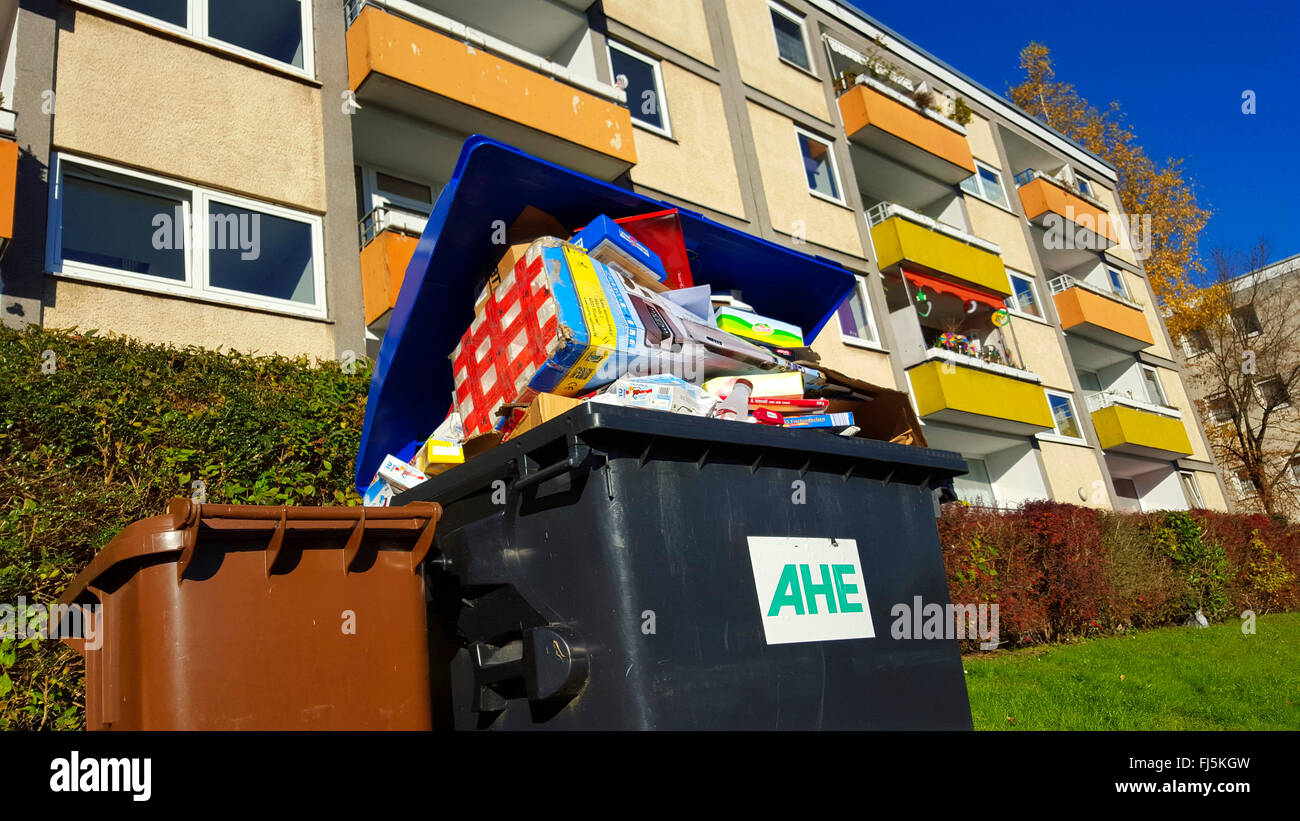 overfilled waste paper container in front of a block of flats, Germany ...