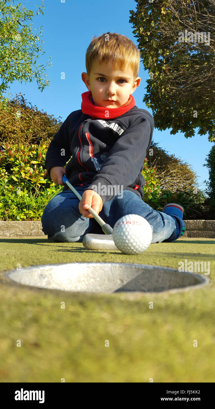 miniature golf, miniature golf ball is holed by a boy, Germany Stock ...