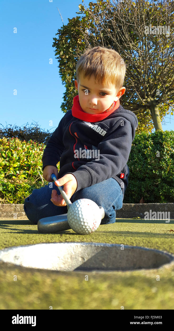 miniature golf, miniature golf ball is holed by a boy, Germany Stock ...
