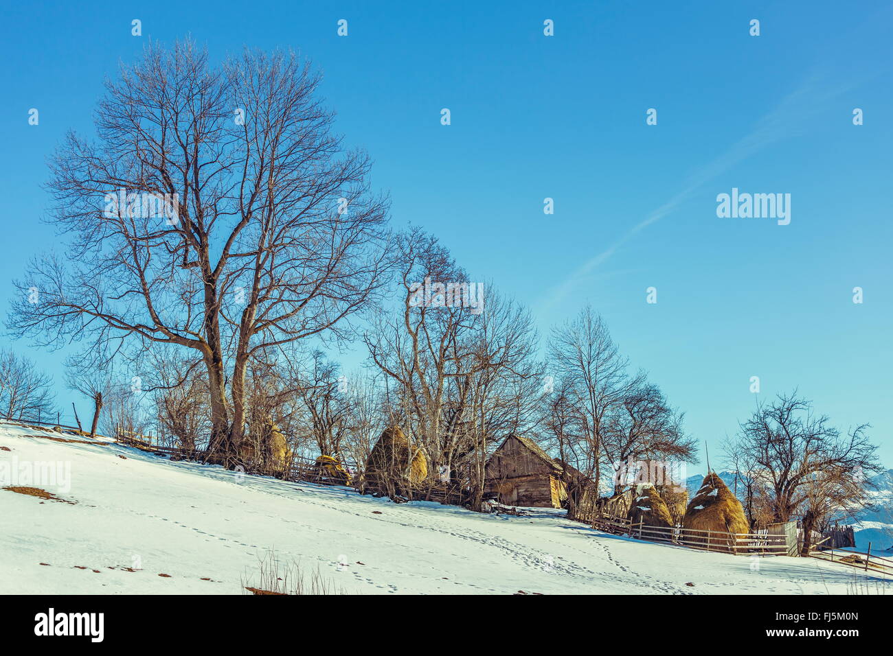Winter landscape with ancient Romanian farm on a sunny morning in ...