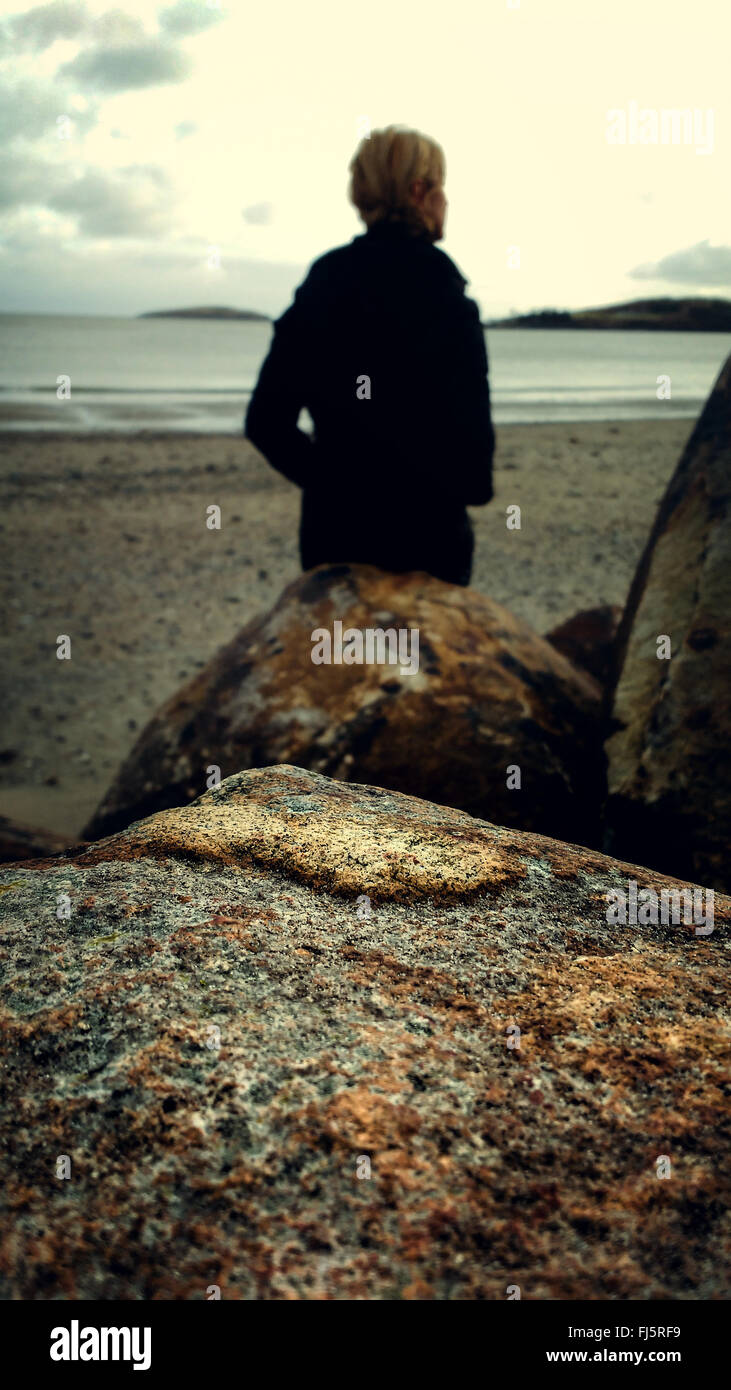 young woman on the beach by the rocks Stock Photo - Alamy