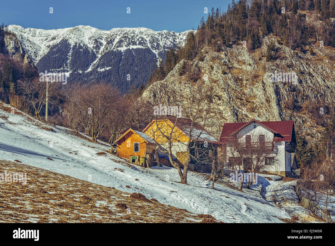 Sunny winter rural scenery with snowy Piatra Craiului mountain ridge ...