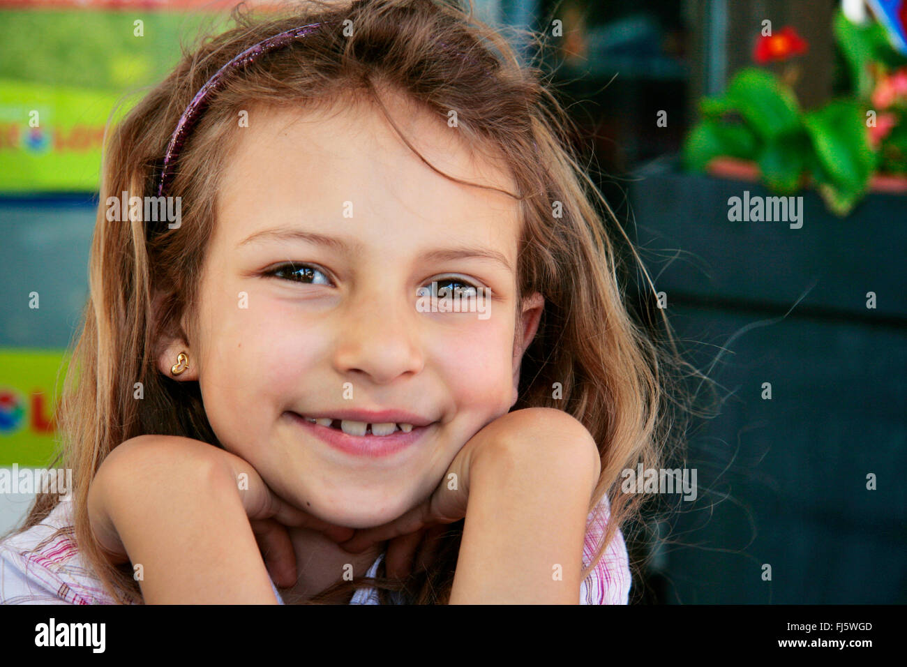 girl in good mood resting head on hands, portrait of a child, Germany ...
