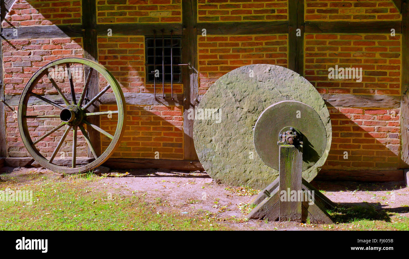 old wheel, millstone and grindstone on a farm, Germany, Lower Saxony ...