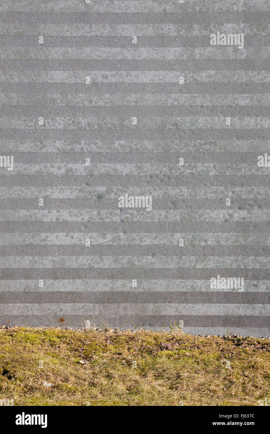Striped stone wall and grass background Stock Photo - Alamy