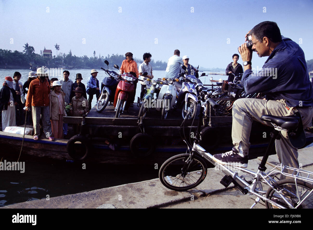 photographer taking pictures of a crowd at a port, Vietnam, Hoi An ...