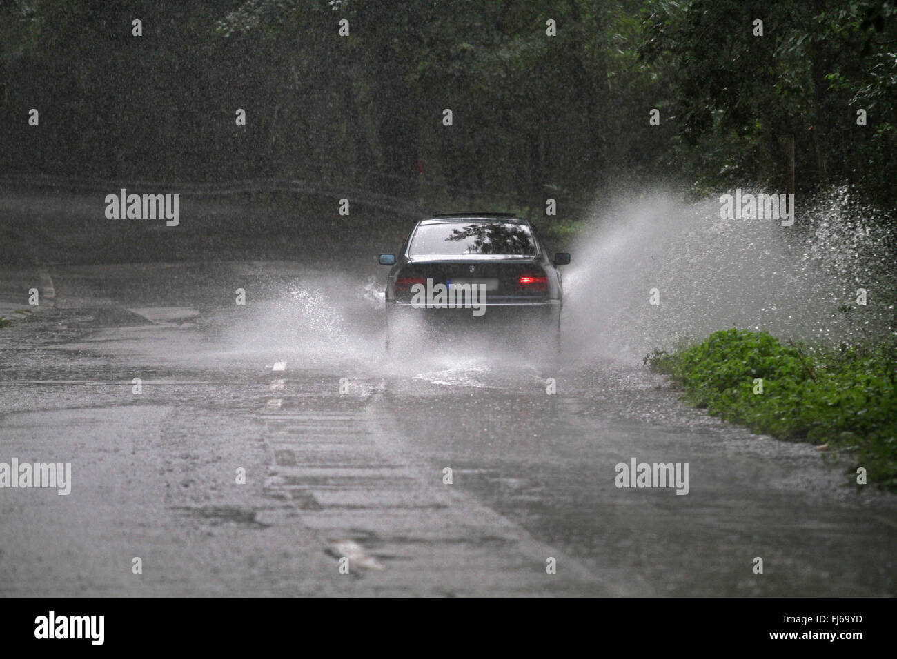 car on flooded road during heavy rain, Germany Stock Photo - Alamy