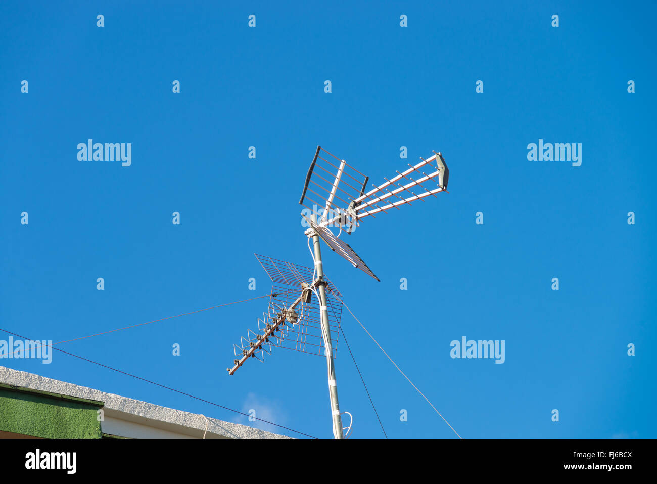 Rooftop tv antenna against blue sky Stock Photo - Alamy