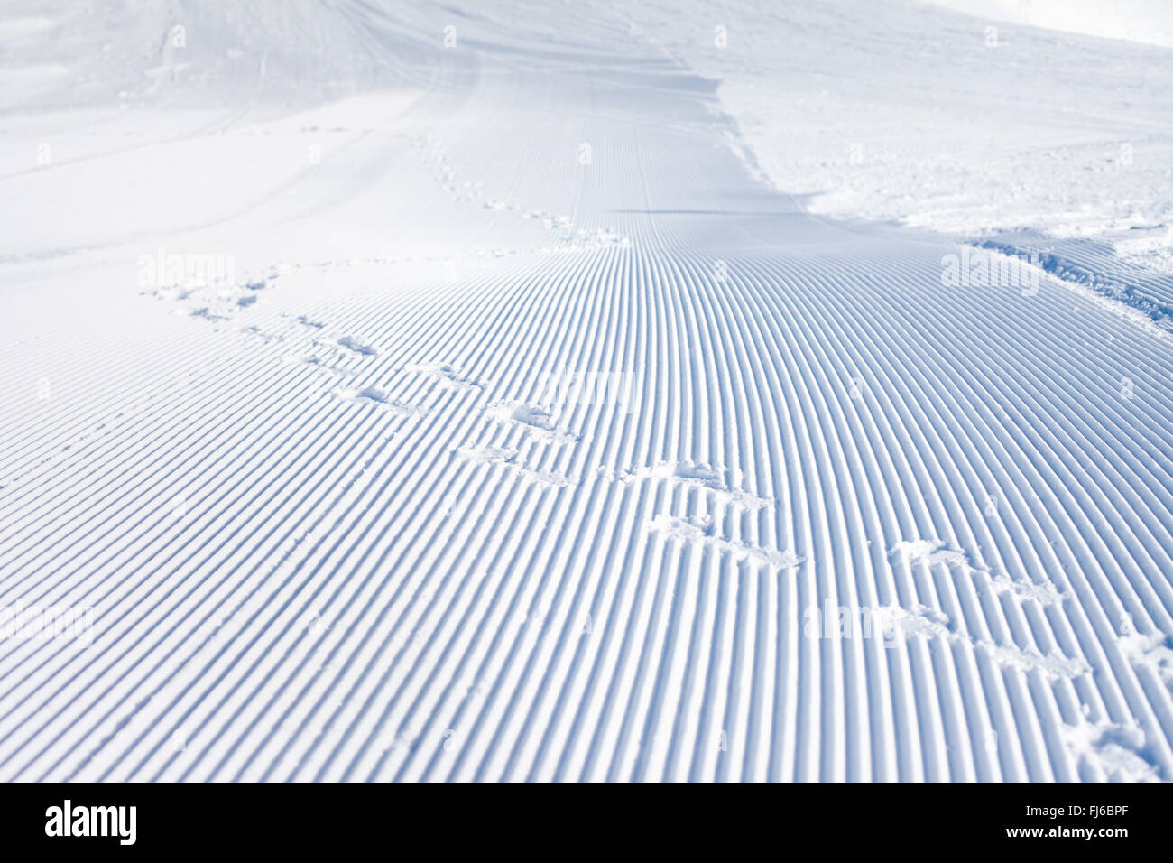 Foot prints in the snow, snow lines made by a snow machine on a ski ...