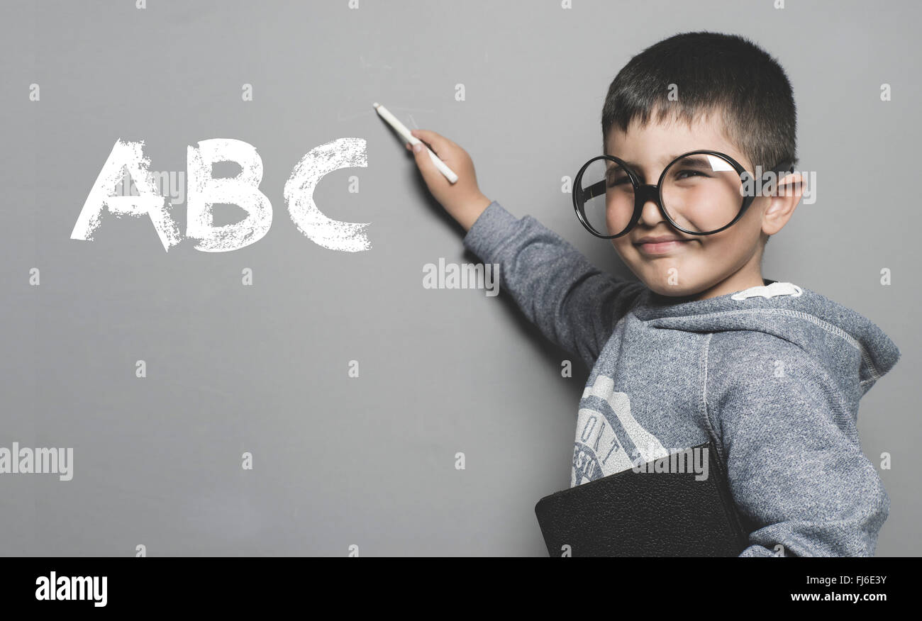 kid with goggles and funny gesture writing on the blackboard the text ...