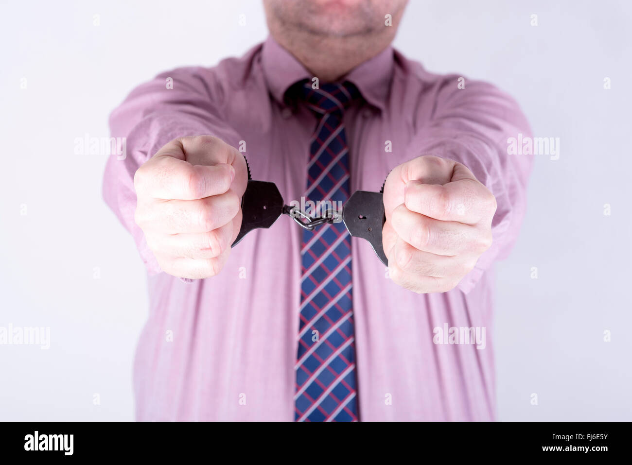 a picture of a businessman locked in handcuffs Stock Photo - Alamy