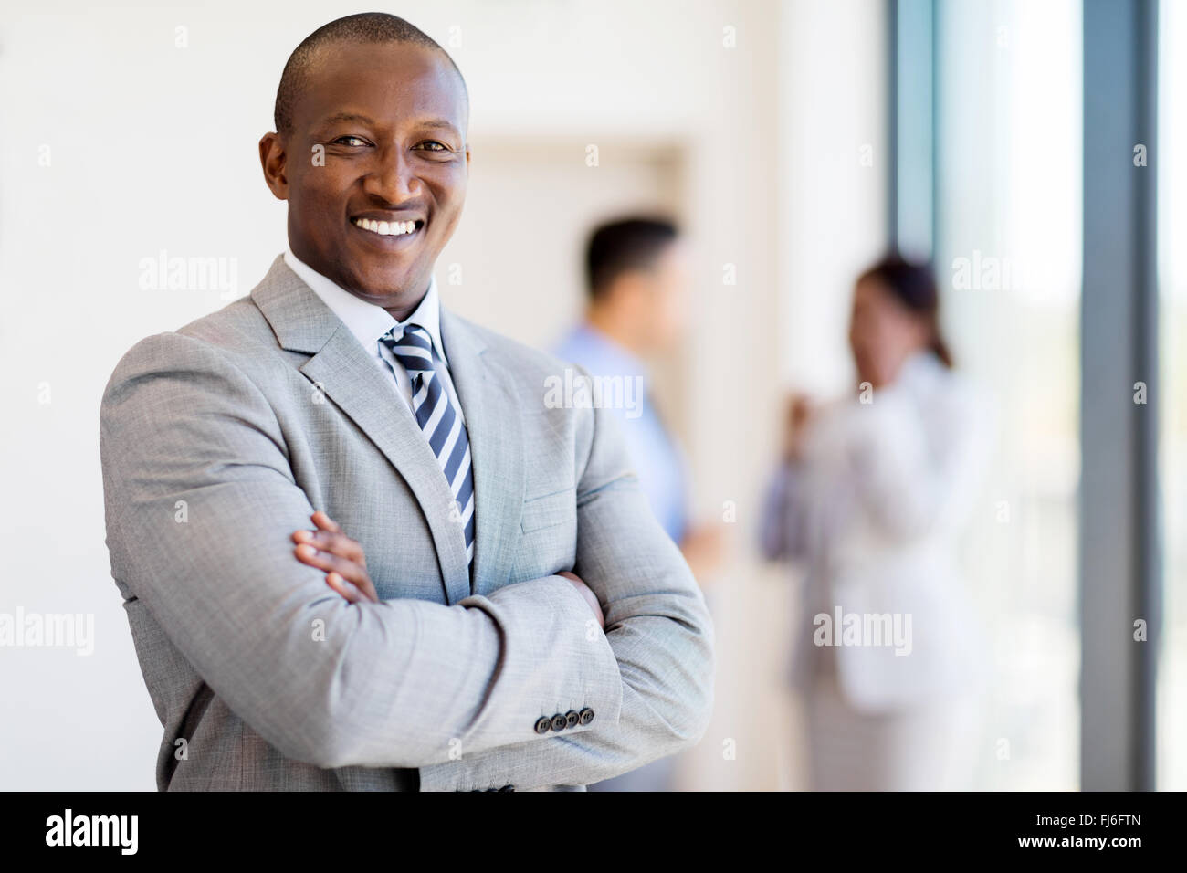 successful African business man with arms folded in modern office Stock ...