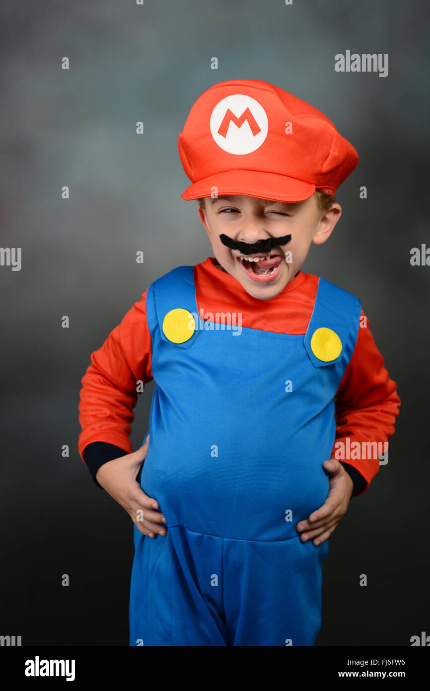 Boy dressed up as Super Mario Bros against gray background Stock Photo ...