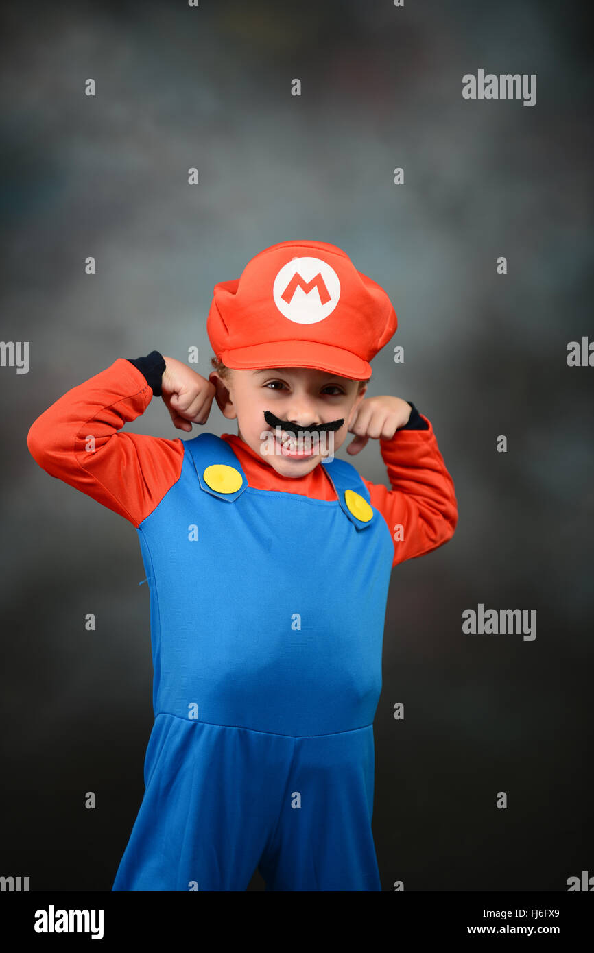 Boy dressed up as Super Mario Bros against gray background Stock Photo ...