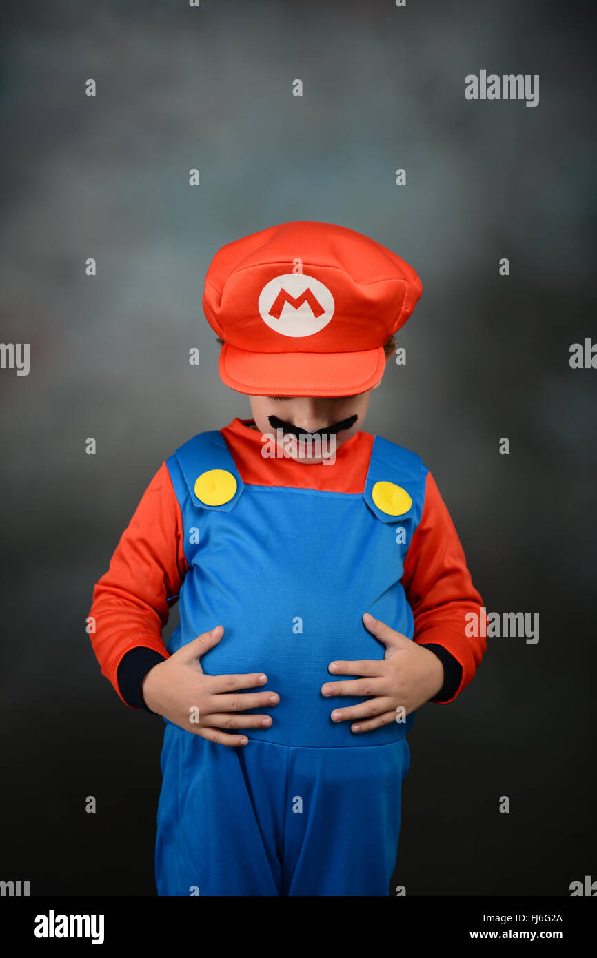 Boy dressed up as Super Mario Bros against gray background Stock Photo ...