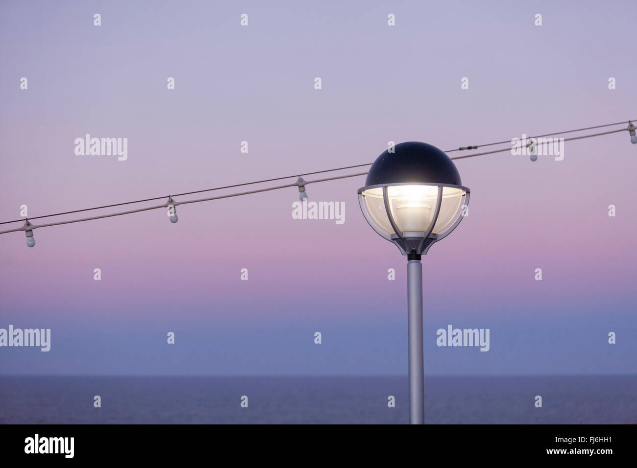 A lamp post lit up at dusk on a cruise ship Stock Photo - Alamy