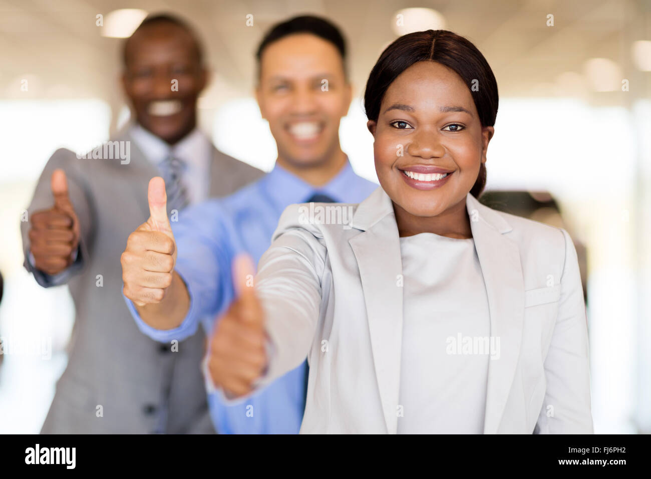 professional vehicle sales team in a row giving thumbs up Stock Photo ...