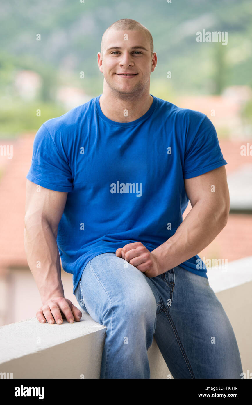 Happy Muscular Man In Blue T-Shirt Standing And Showing His Muscle ...