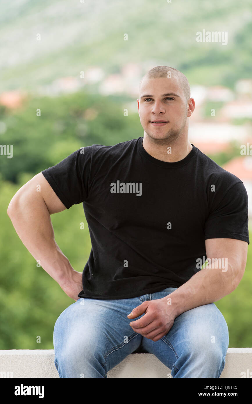 Happy Muscular Man In Black T-Shirt Standing And Showing His Muscle ...