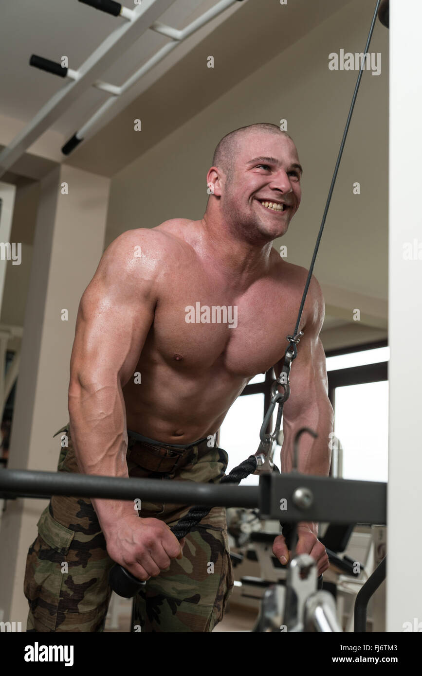 Muscular Man Doing Heavy Weight Exercise For Triceps On Machine In Gym ...