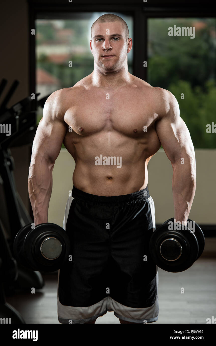 Bodybuilder Doing Heavy Weight Exercise For Biceps With Dumbbells In ...