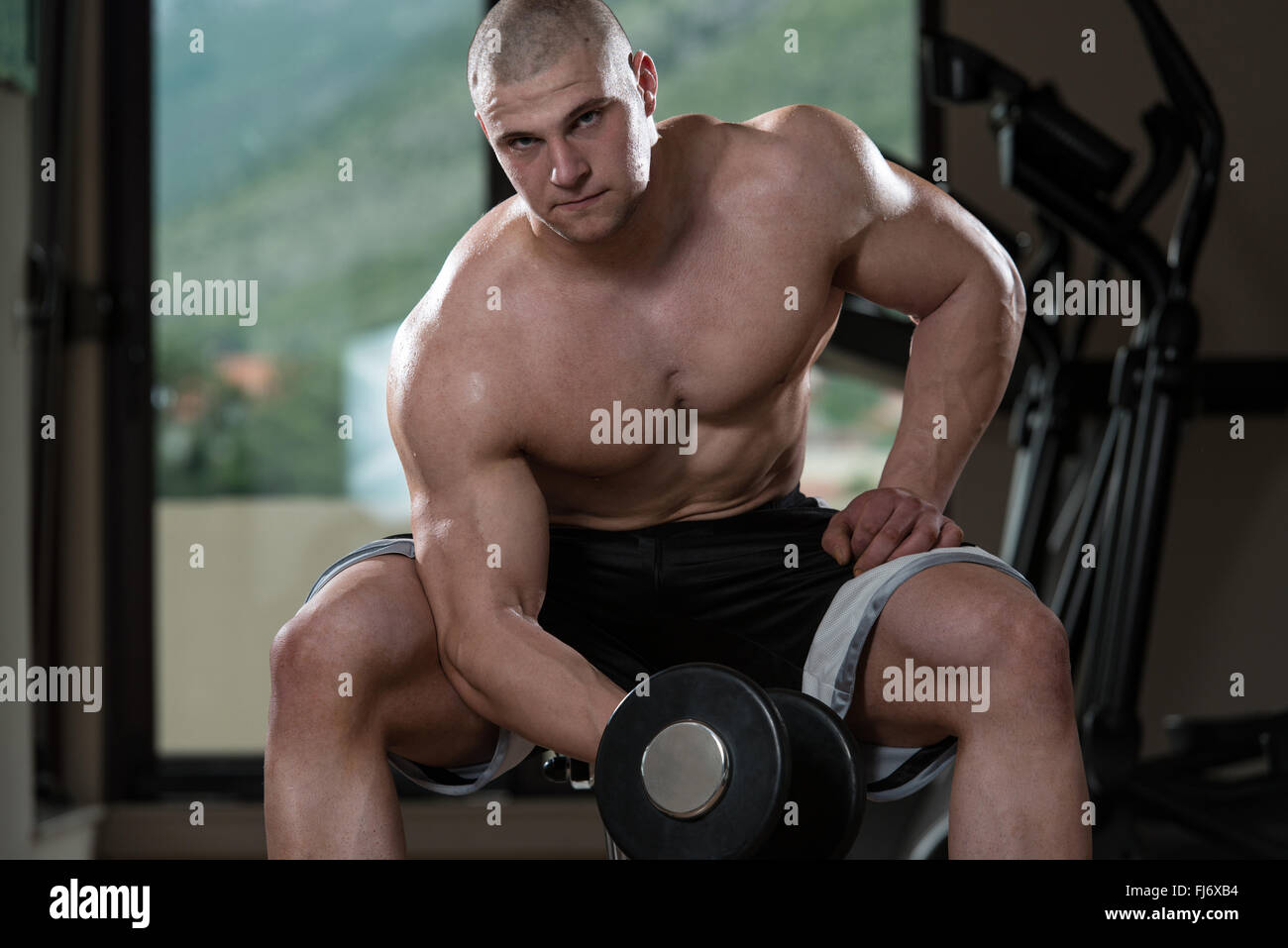 Bodybuilder Doing Heavy Weight Exercise For Biceps With Dumbbells In ...