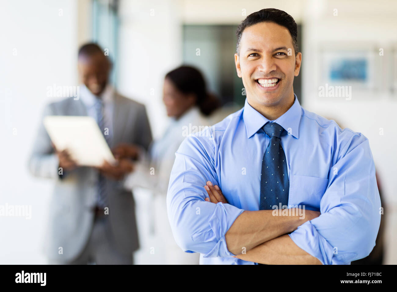 good looking corporate worker in modern office with colleagues on ...