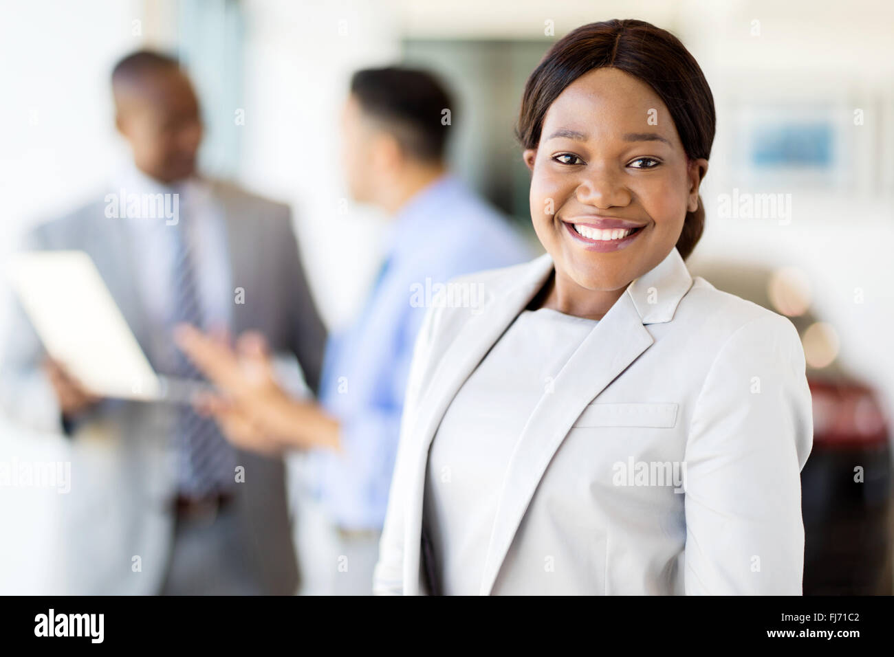 pretty African American female vehicle sales consultant standing in ...