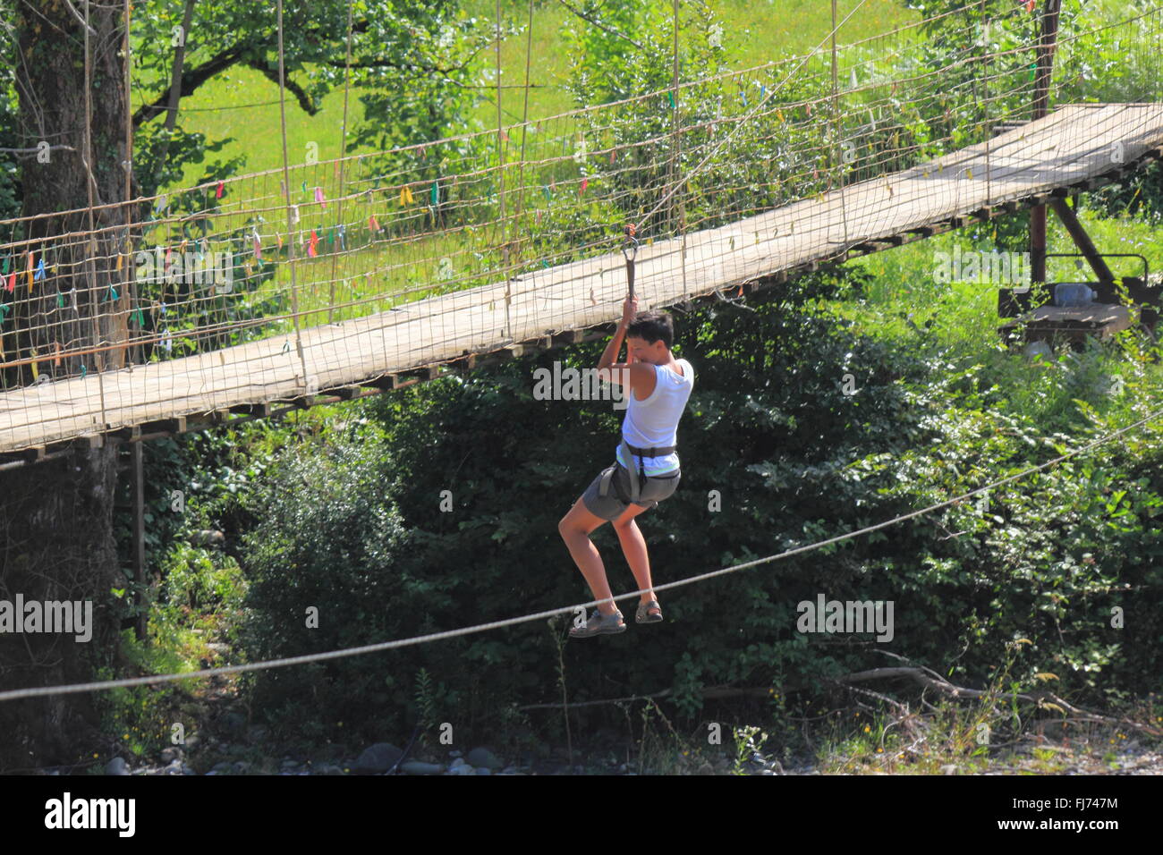 Suspension bridge and hand hanging crossing through the mountain river ...