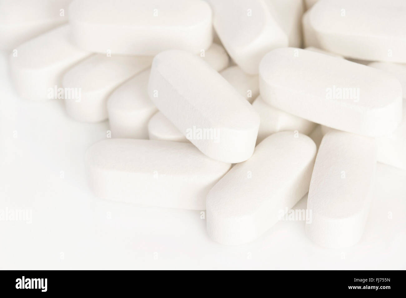 A pile of calcium vitamin supplement tablets isolated on a white ...