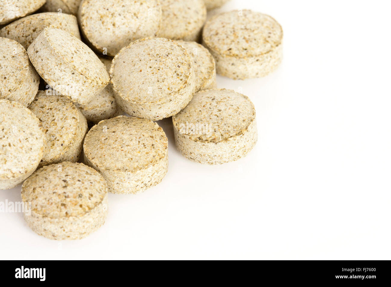 A pile of sea kelp vitamin supplement tablets isolated on a white ...