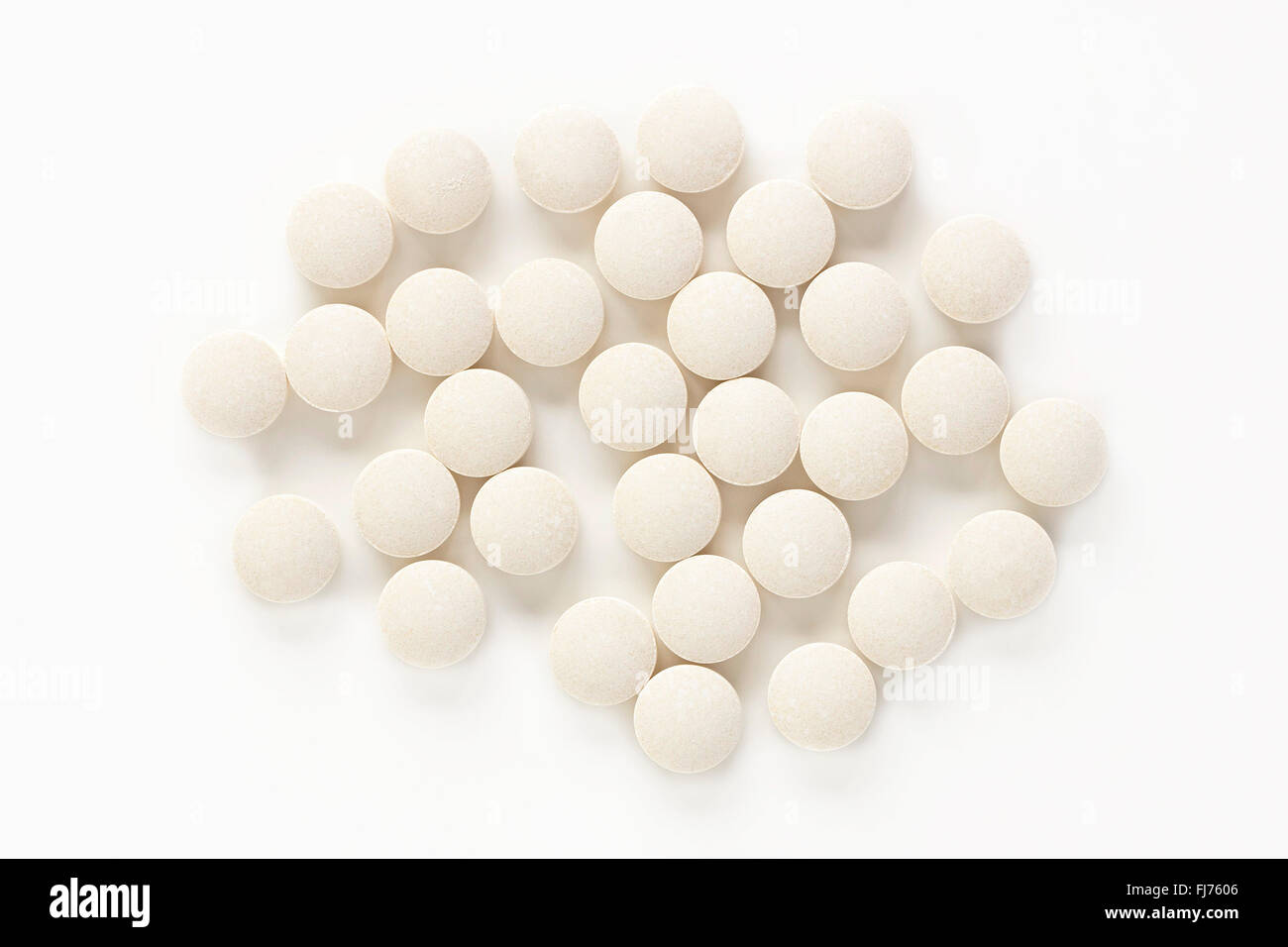A pile of selenium vitamin supplement tablets isolated on a white ...