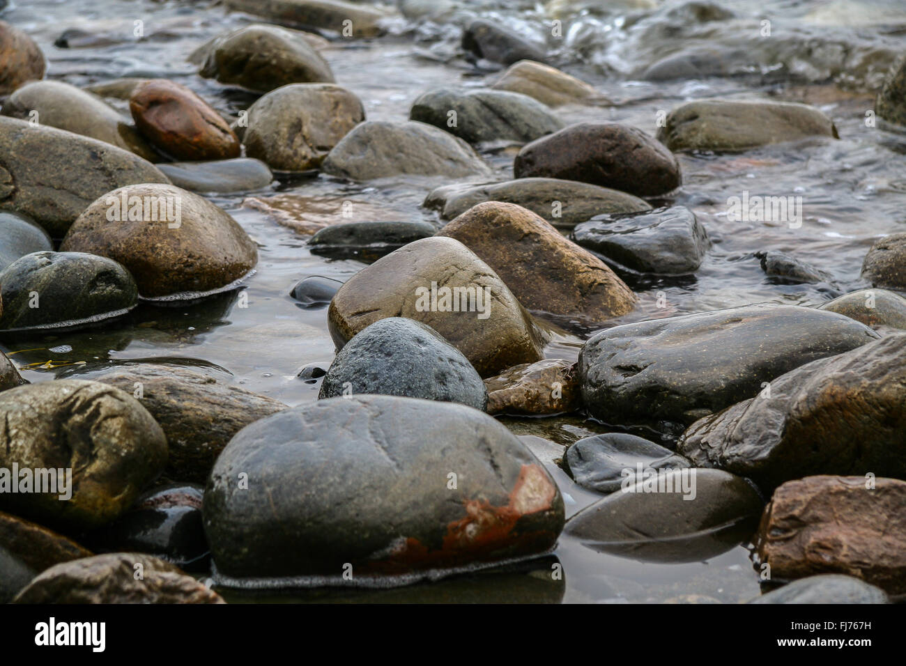 stones on lake shore with differente colors Stock Photo - Alamy