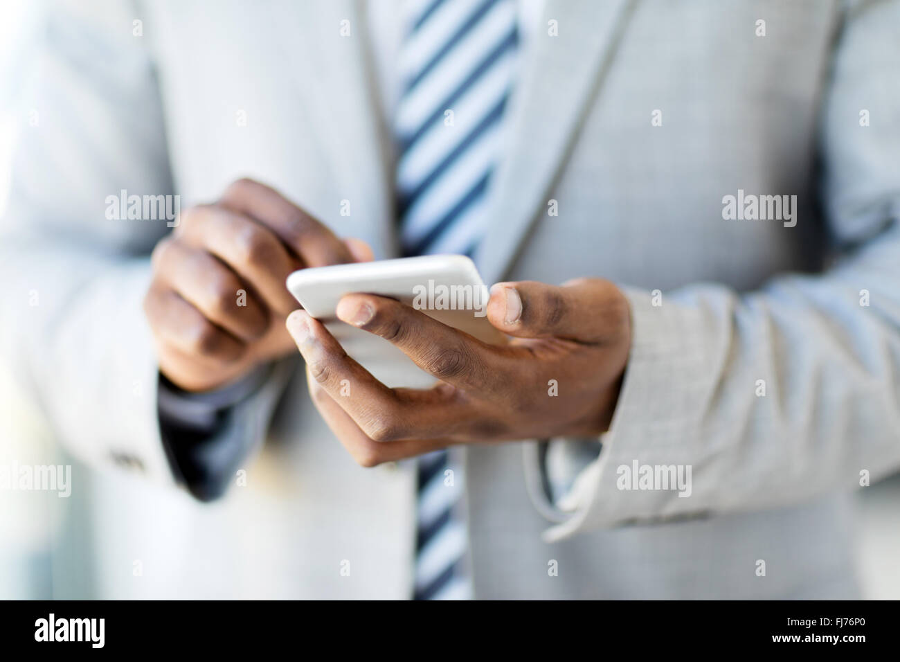 closeup African man using cell phone in office Stock Photo - Alamy