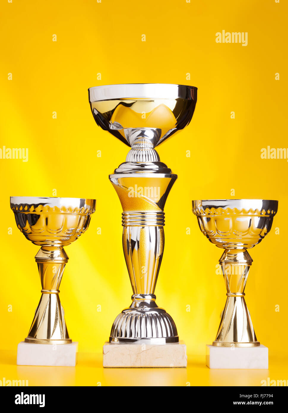 Three winner cup bowl prizes on gold background Stock Photo - Alamy