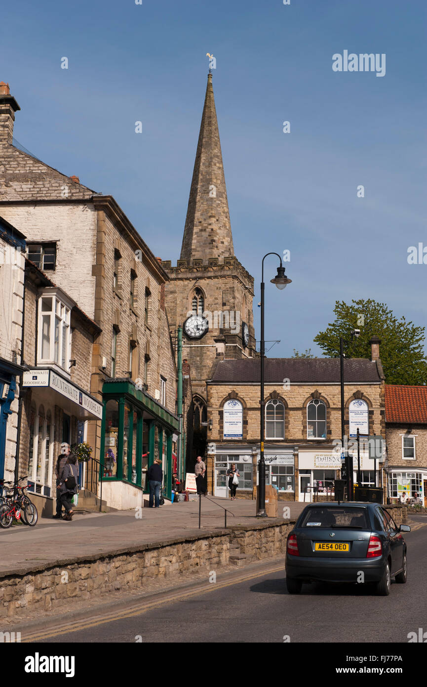 Under a blue sky & by the church, people are window shopping in local ...