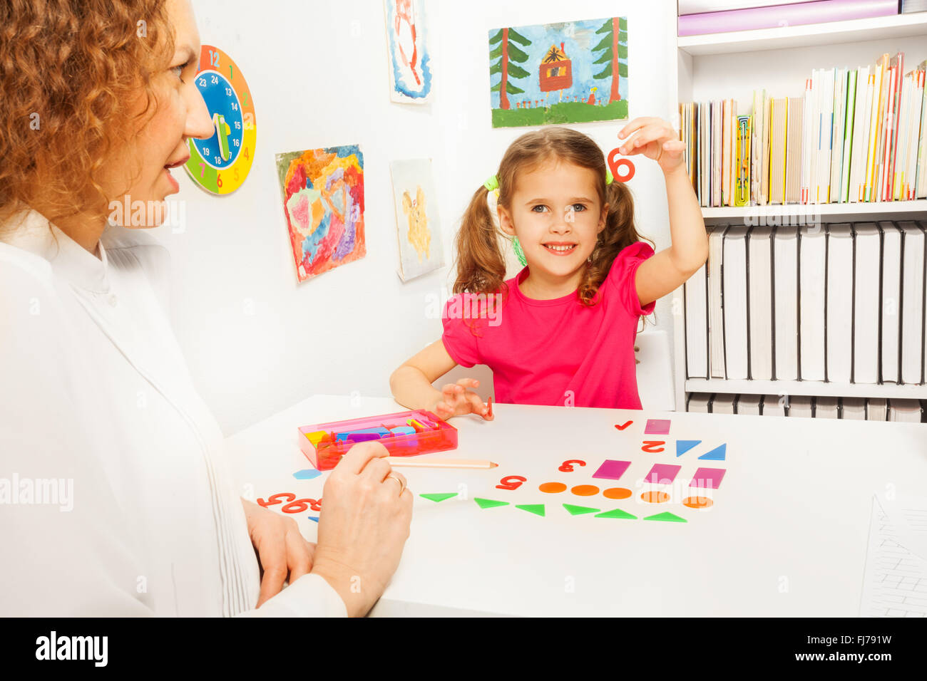 Pupil studying math in classroom with teacher Stock Photo - Alamy