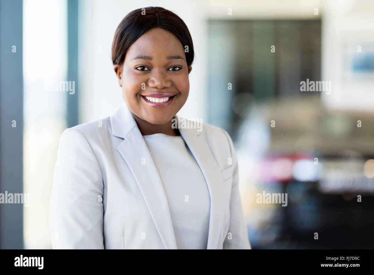 beautiful African saleswoman standing at car dealership Stock Photo - Alamy