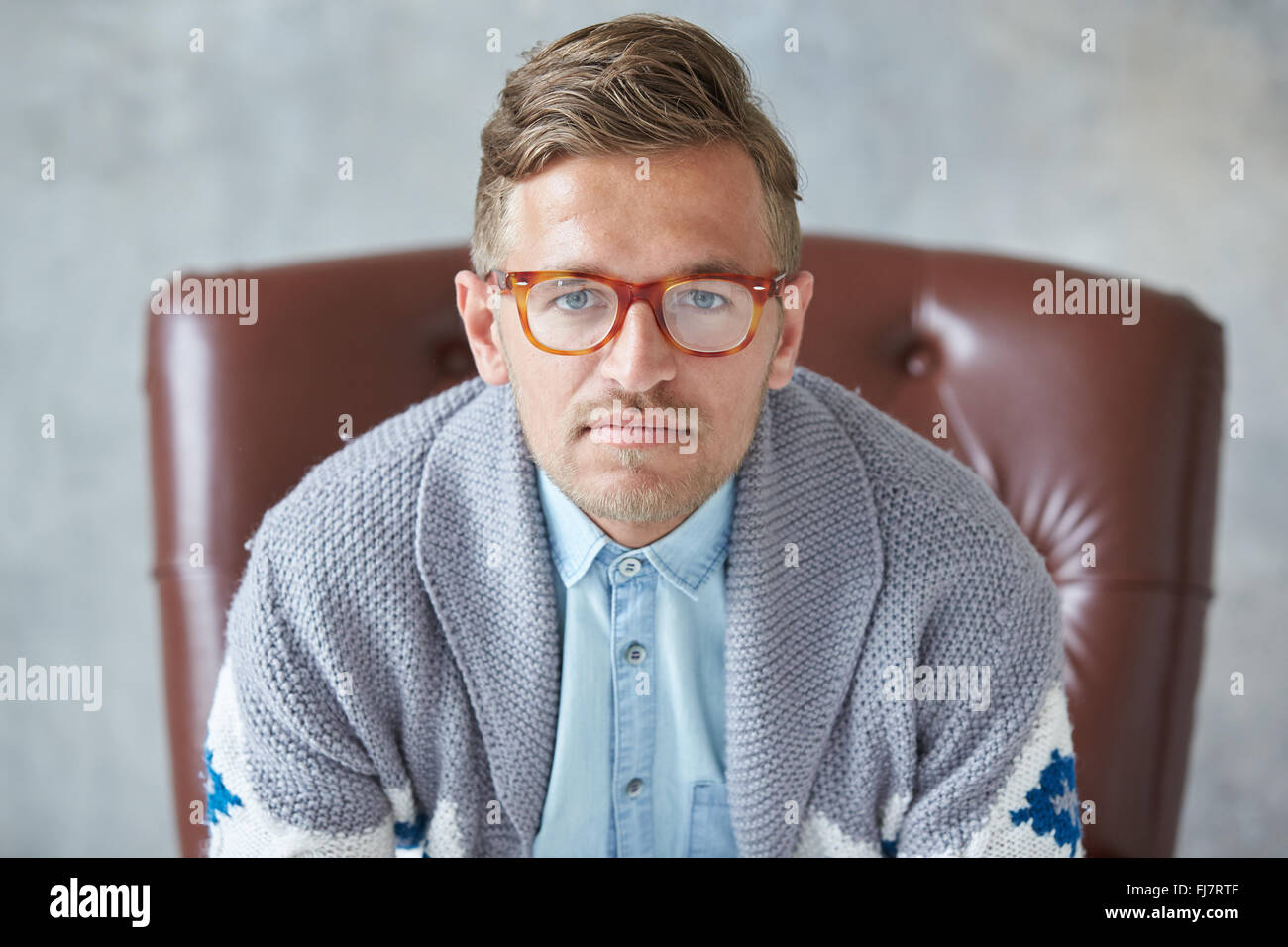 Portrait of a stylish intelligent man with glasses stares into the ...