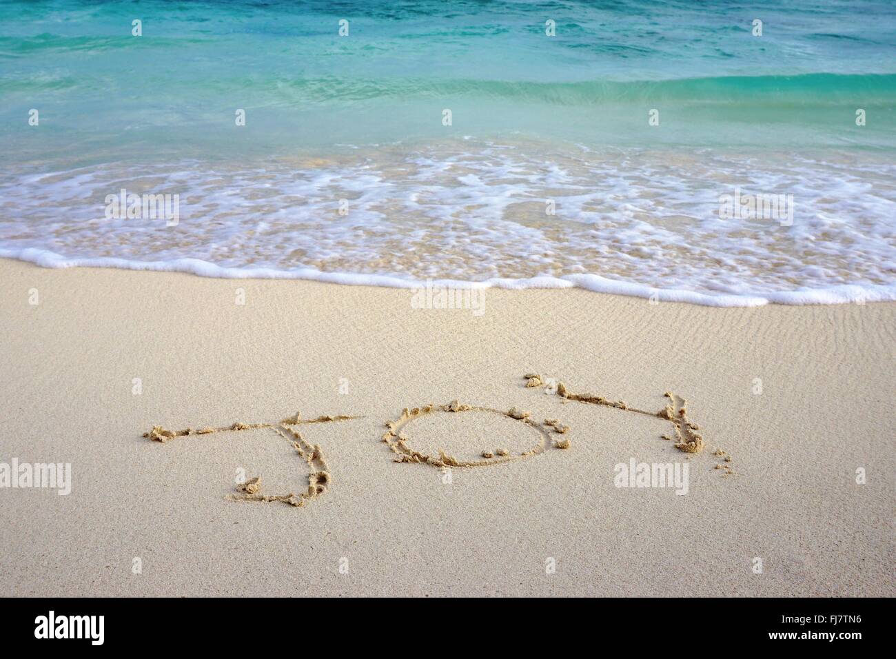 "Joy" written in the sand on the beach Stock Photo - Alamy