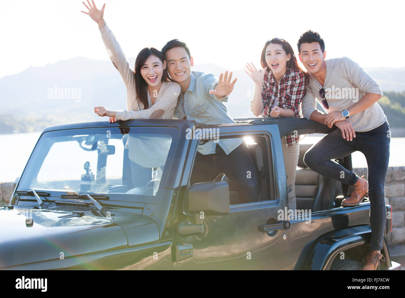 Chinese friends having fun in a jeep Stock Photo - Alamy