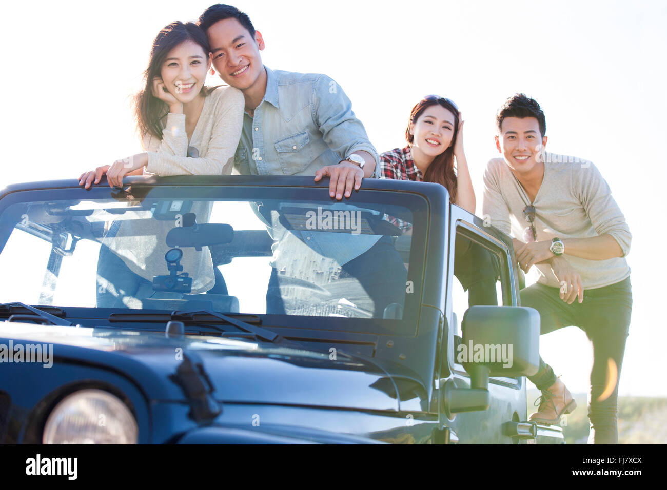 Chinese friends having fun in a jeep Stock Photo - Alamy