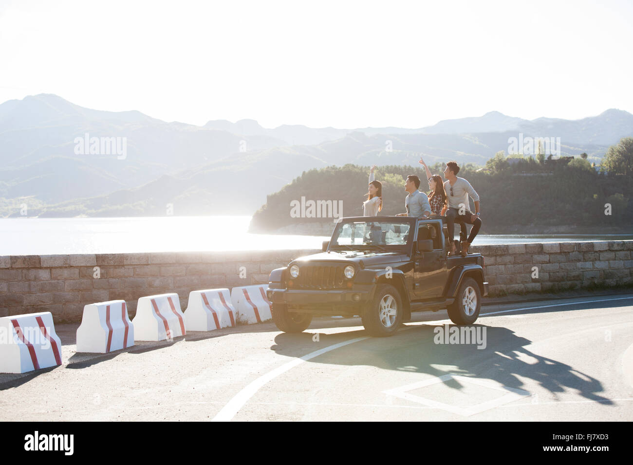 Chinese friends having fun in a jeep Stock Photo - Alamy