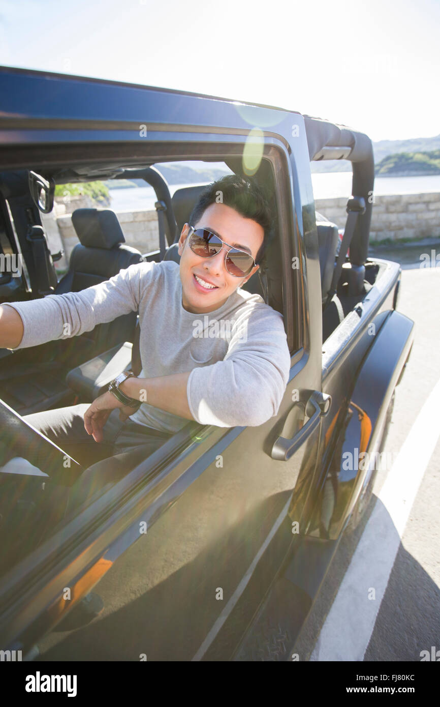 Happy young Chinese man driving a jeep Stock Photo - Alamy