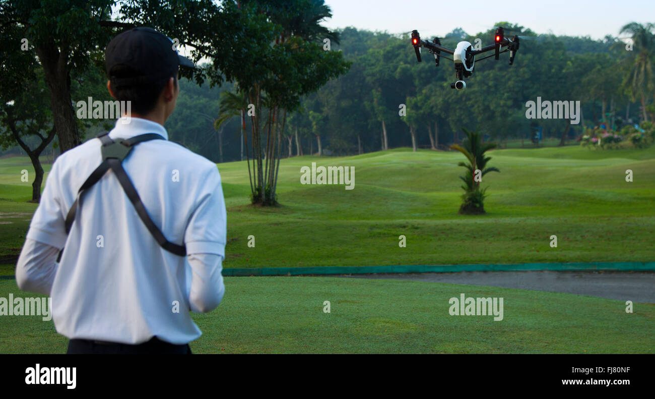 Asian men flying a drone in a park Stock Photo - Alamy