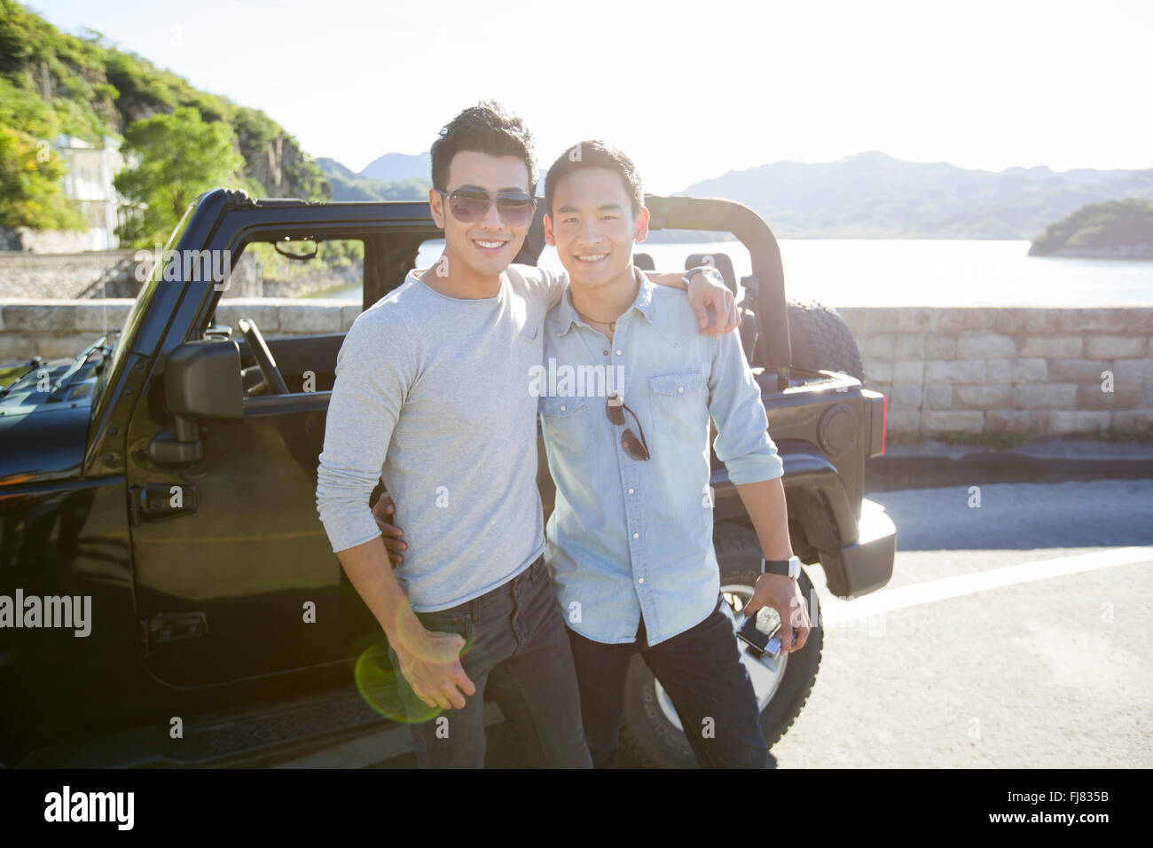 Happy young Chinese men and jeep Stock Photo - Alamy